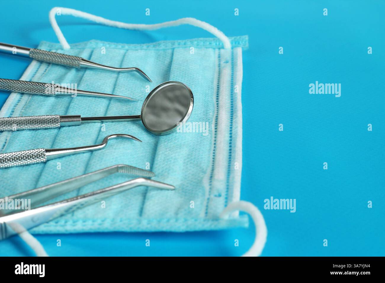 Collection of dental instruments on blue background. Dental mirror ...