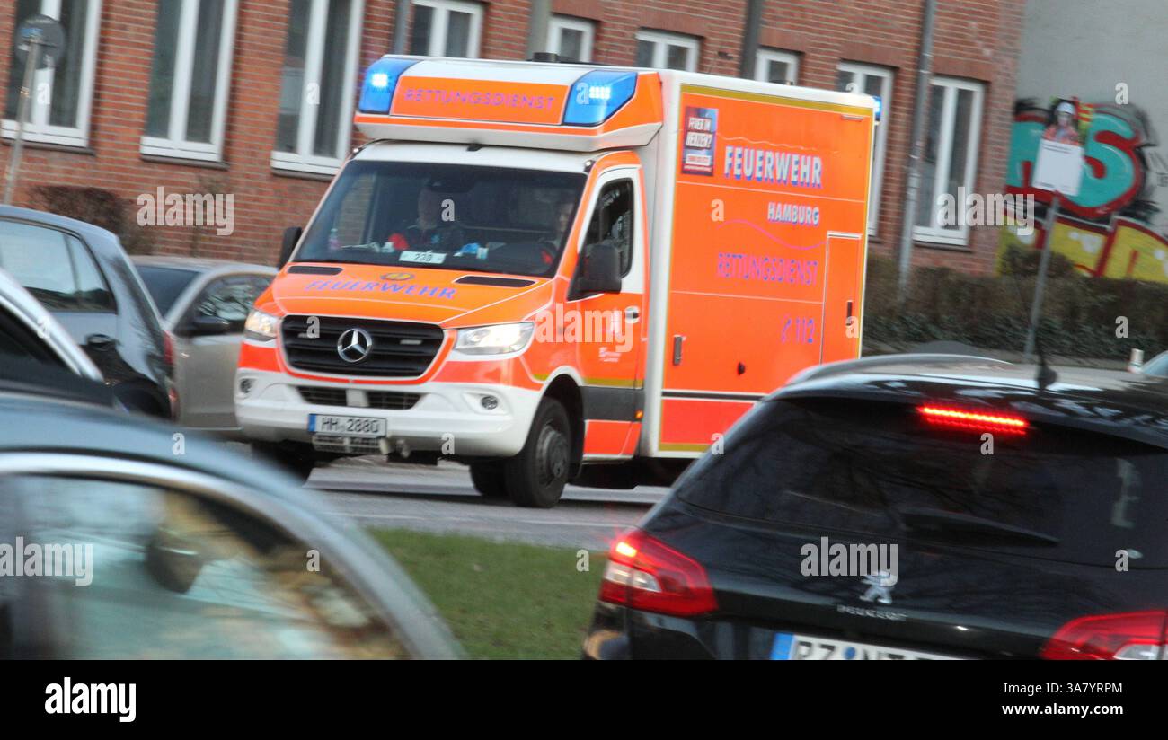 Ein Rettungswagen der Hamburger Feuerwehr fährt mit Blaulicht die ...
