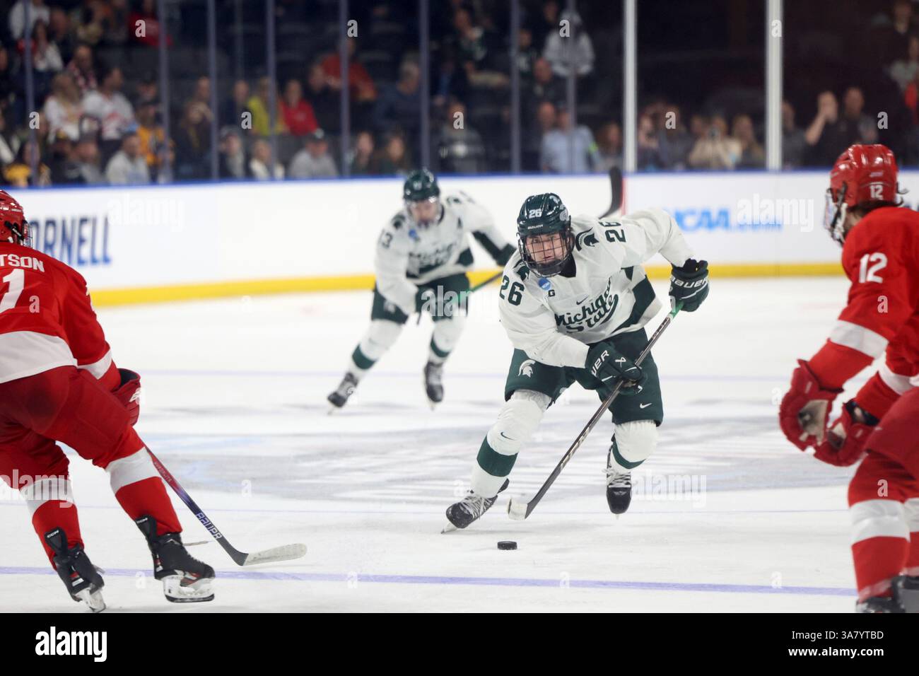 Michigan State's Tanner Kelly (26) advances the puck against Cornell ...