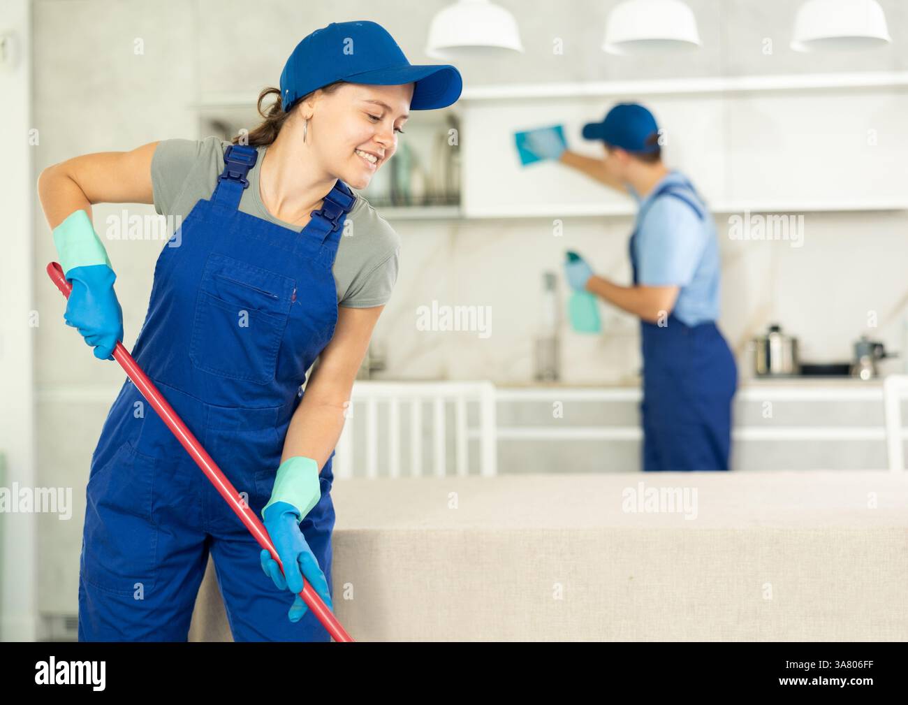 Cleaning lady washes kitchen floor in client house until it shines ...