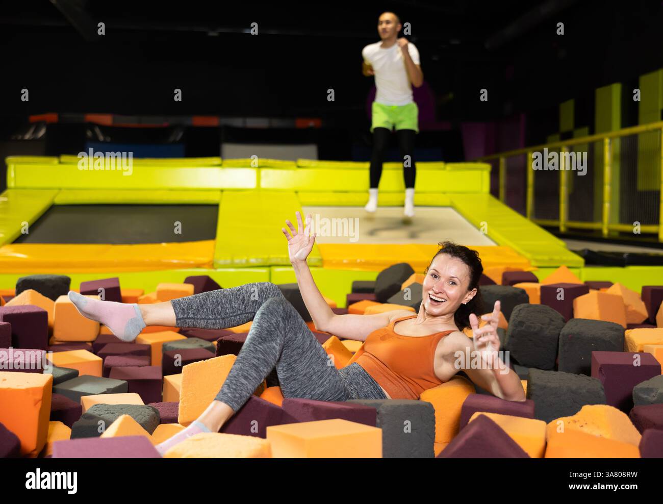 Happy woman jumping into foam cube pit at indoor trampoline park Stock Photo - Alamy