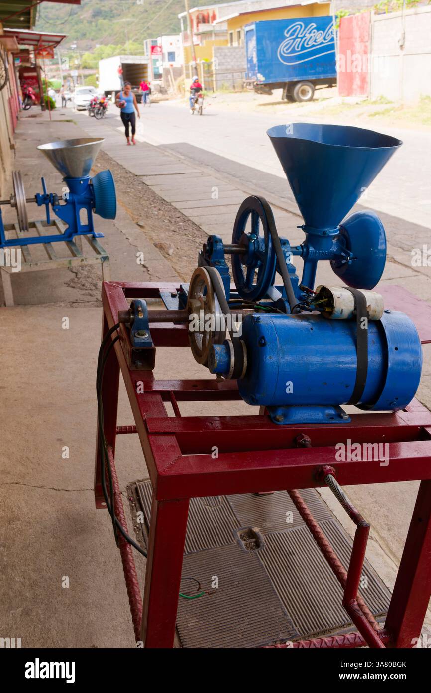 Coffee processing machinery on sidewalk in front of small coffee ...