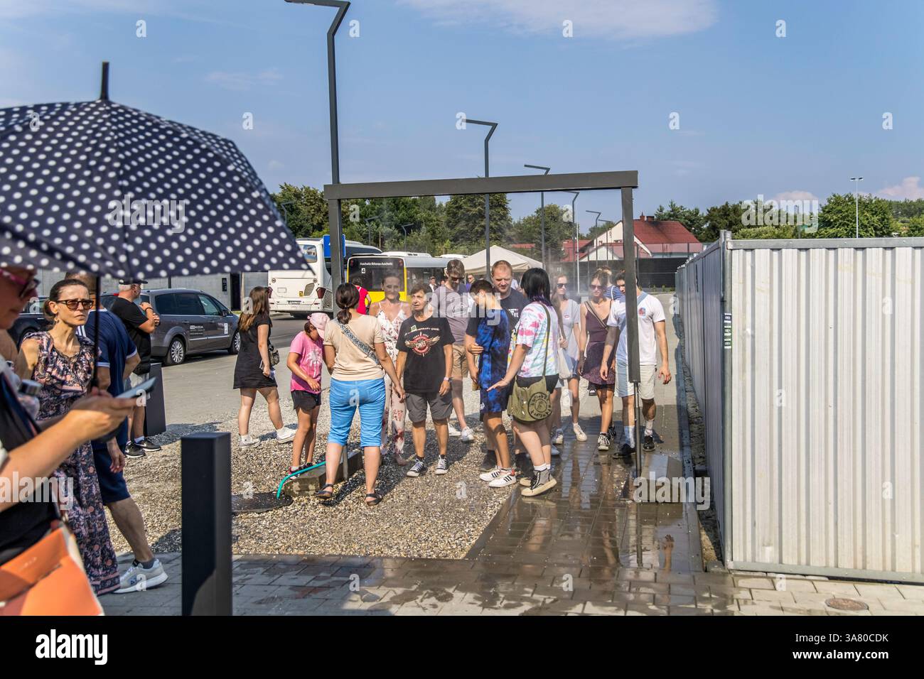 Auschwitz, Poland- July 16, 2023: Visitors walk past outdoor water mist ...