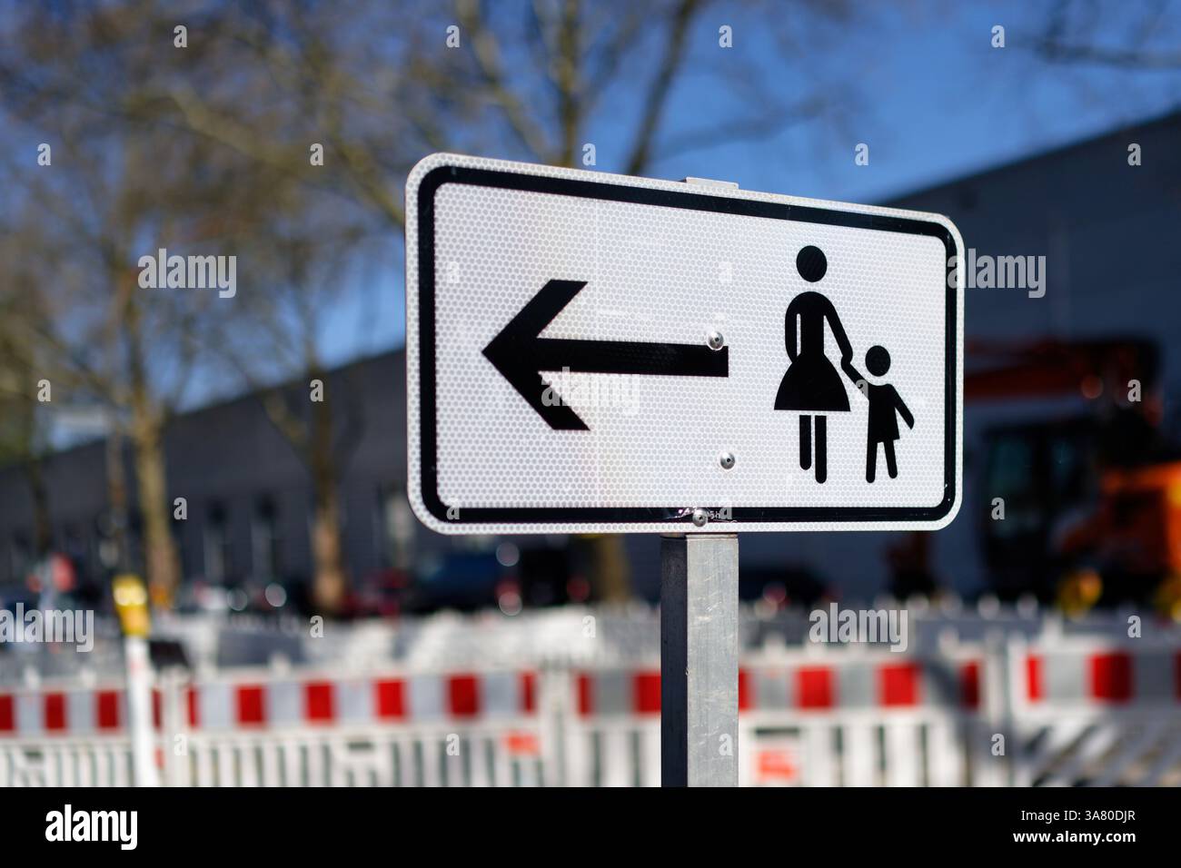 A white traffic sign with an arrow and a pictogram of a woman with a ...