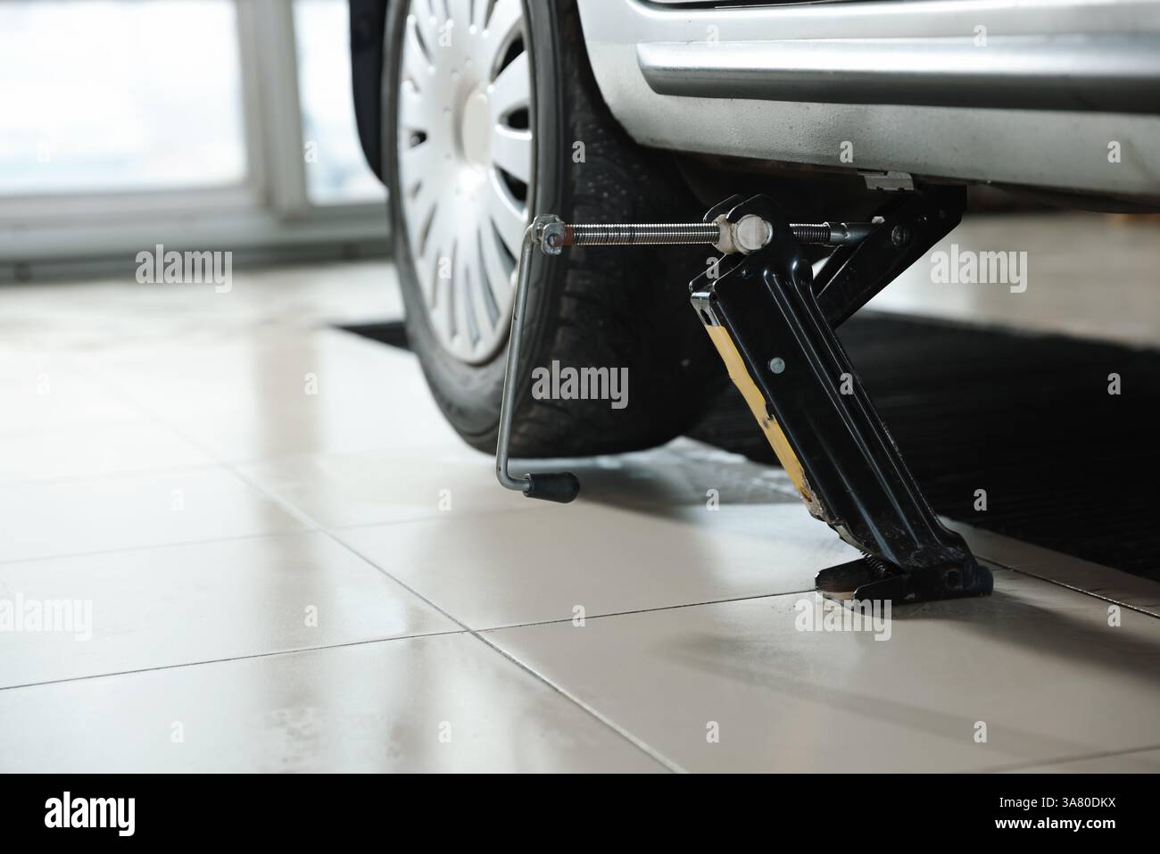 Car lifted by scissor jack at service station, space for text Stock ...