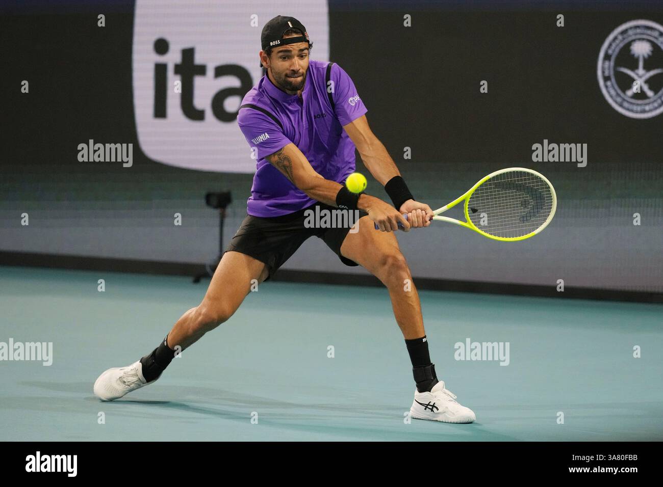 Matteo Berrettini of Italy hits a return to Taylor Fritz during the Miami Open tennis tournament ...