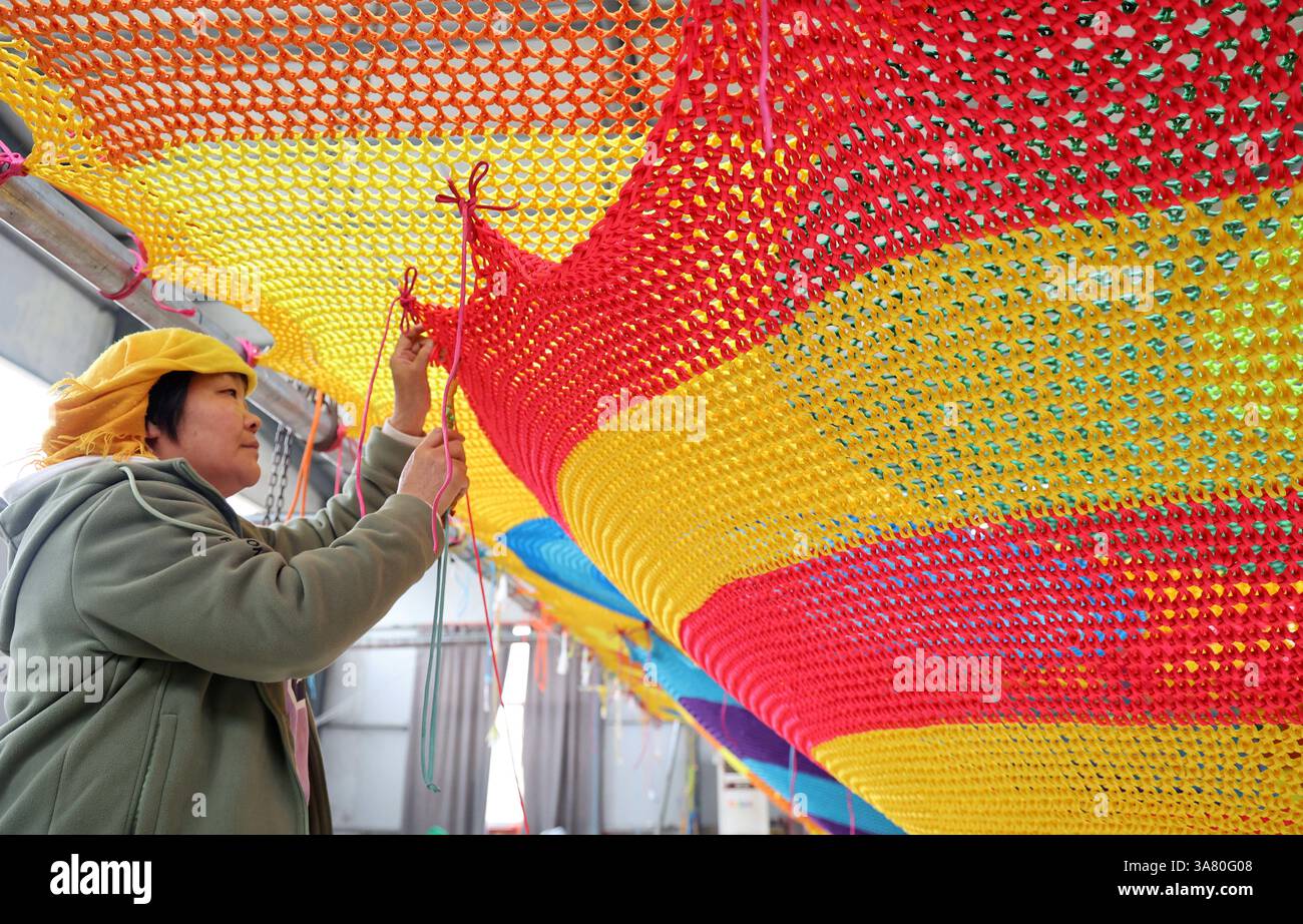 A worker produces rope net products for export at a workshop of a rope ...