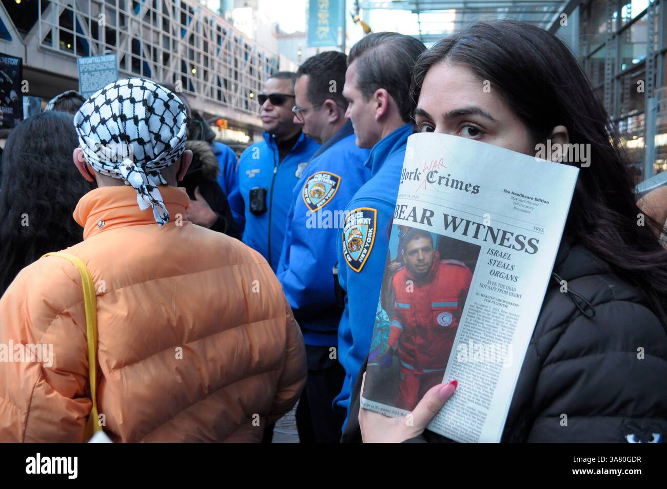 A pro-Palestine demonstrator holds a pro-Palestine publication at a ...