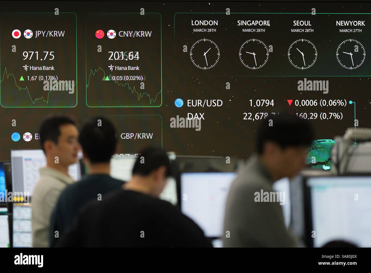 Currency traders work near the screens showing the foreign exchange ...