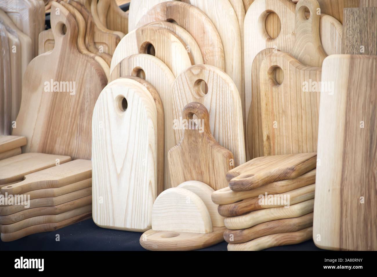 Close-up of handmade wooden cutting boards stacked in a variety of ...