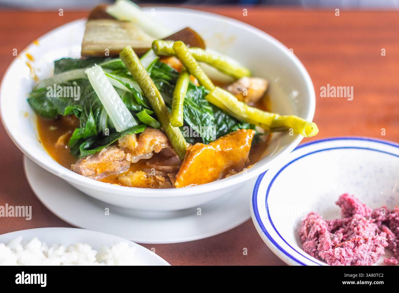 A dish of kare-kare, a beloved Filipino stew with peanut sauce, served ...