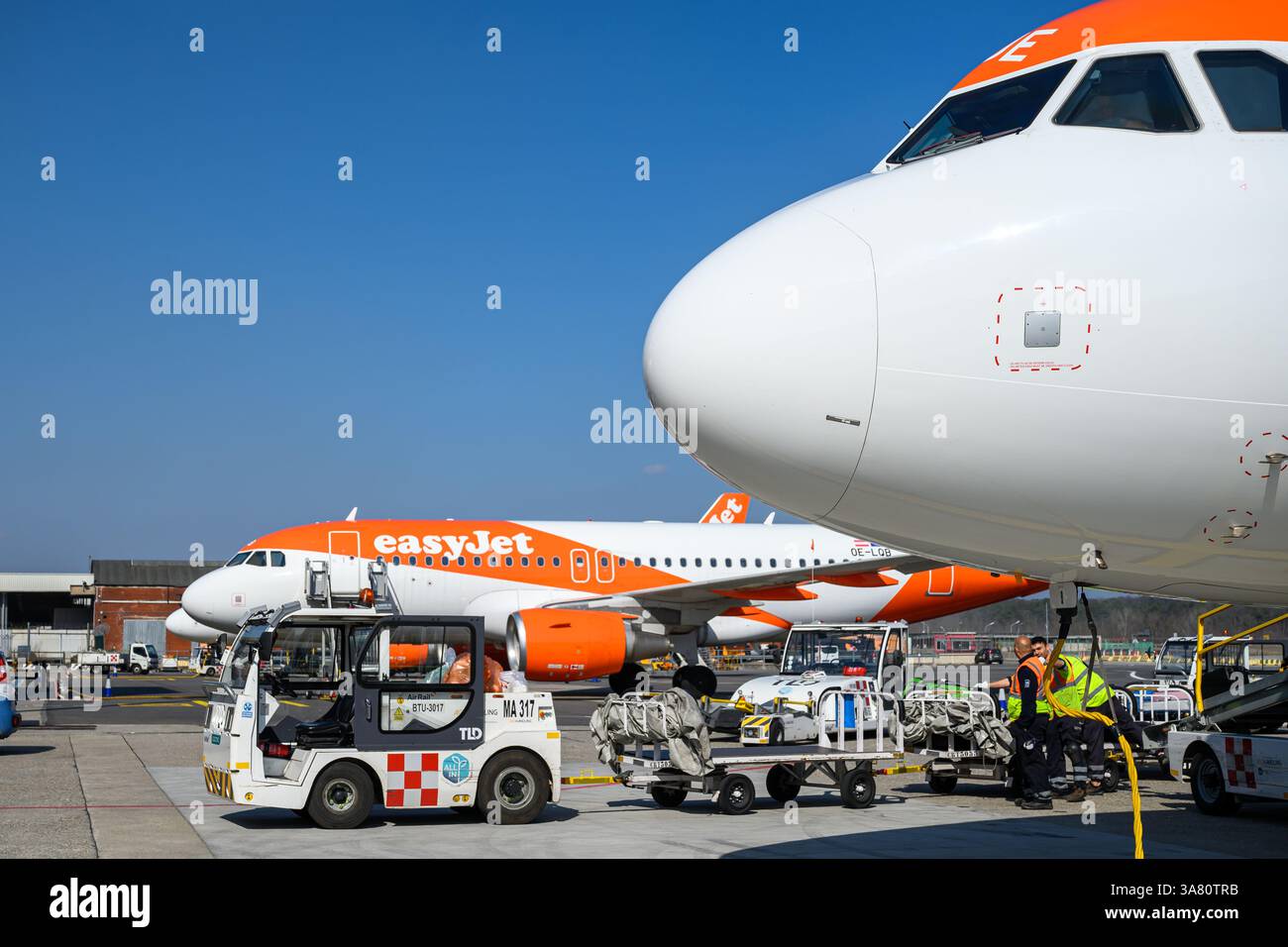 Easyjet planes parked on runway with a baggage tractor – Milan, Italy ...