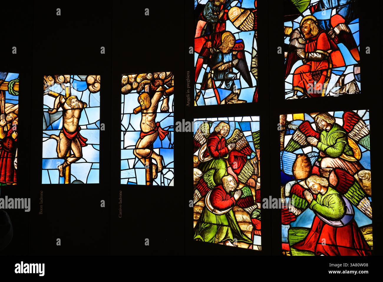Dark room with many stained glass windows inside the Duomo Milan museum ...