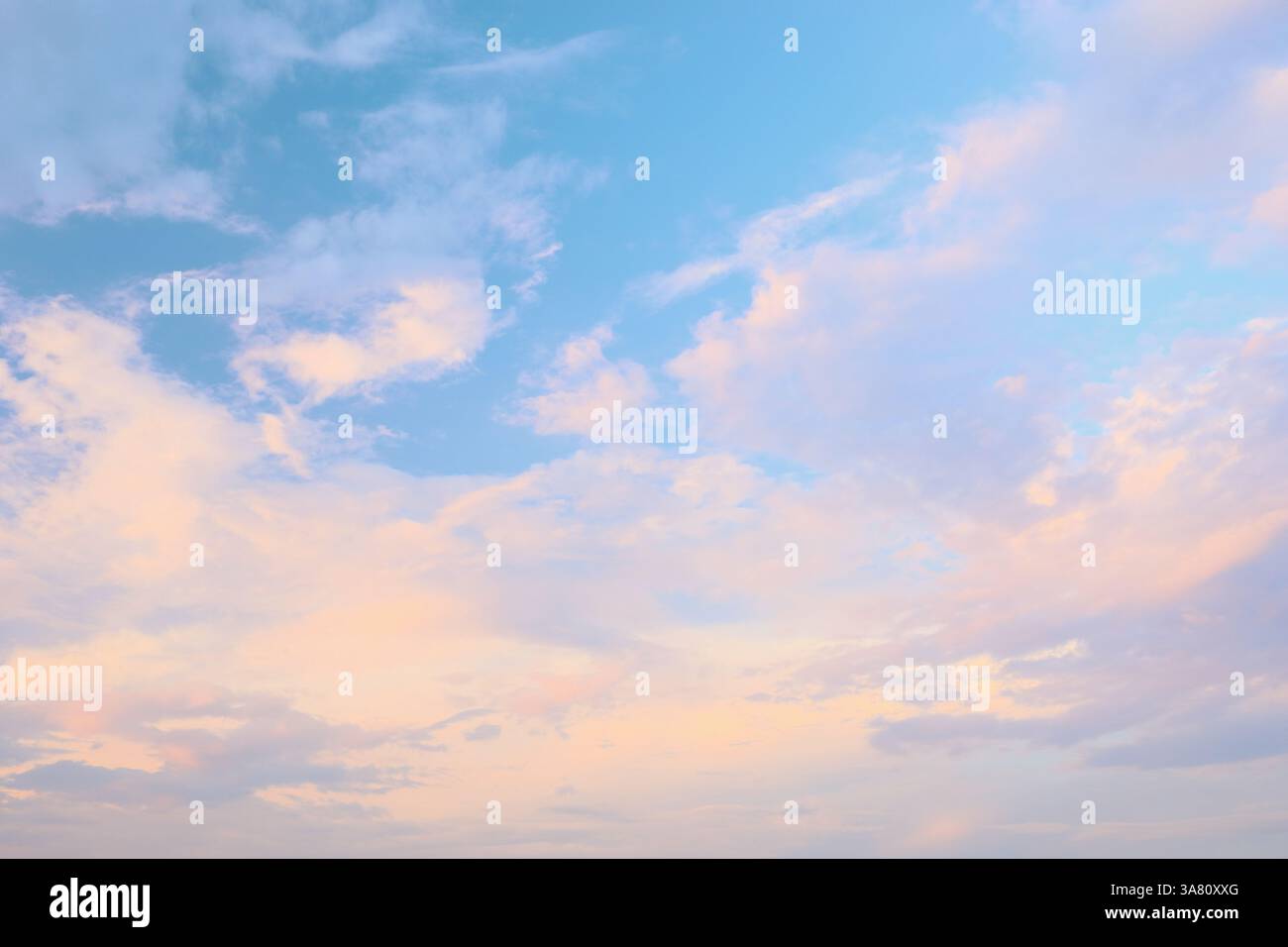 Soft pastel colors fill the sky as clouds drift gently during sunset ...