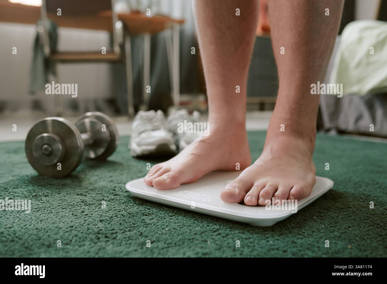 Stepping on Scale in Home Gym Setting Stock Photo - Alamy
