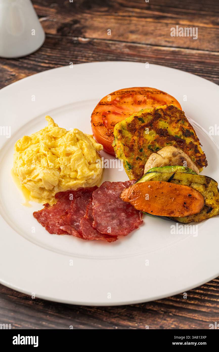 Rustic breakfast plate with fried eggs, grilled vegetables, and turkey ...