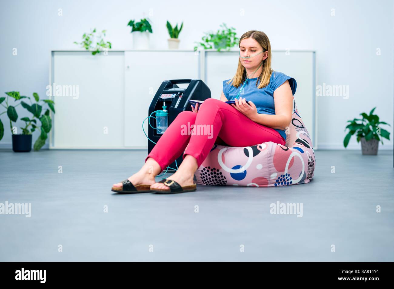 Oxygen therapy, supplemental oxygen. Young woman inhaling oxygen ...