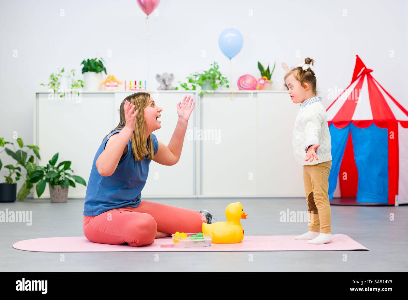 Toddler girl with Down syndrome in child occupational therapy session ...