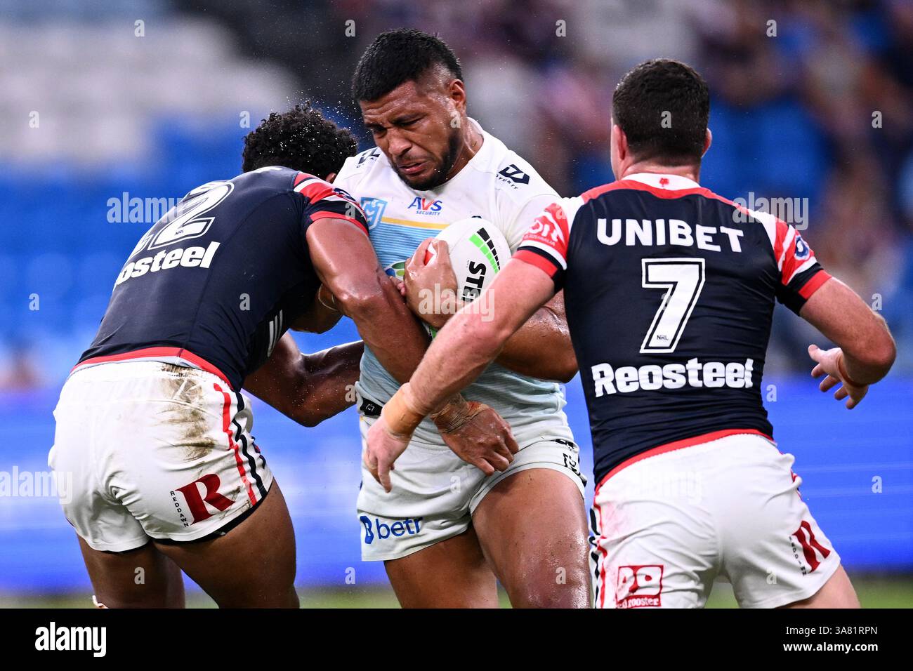 Moeaki Fotuaika of the Titans is tackled by Siua Wong of the Roosters ...