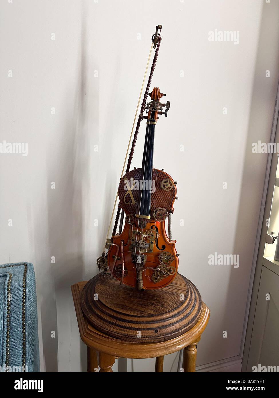 Steampunk violin sculpture with mechanical details on wooden pedestal ...