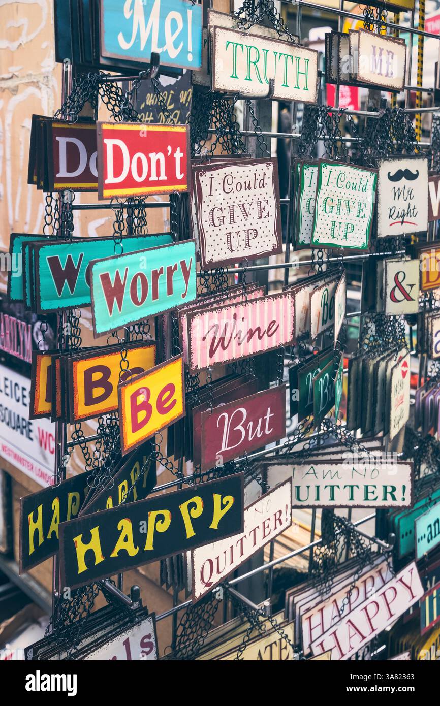 Decorative hanging signs with text on display at Brick Lane market in ...