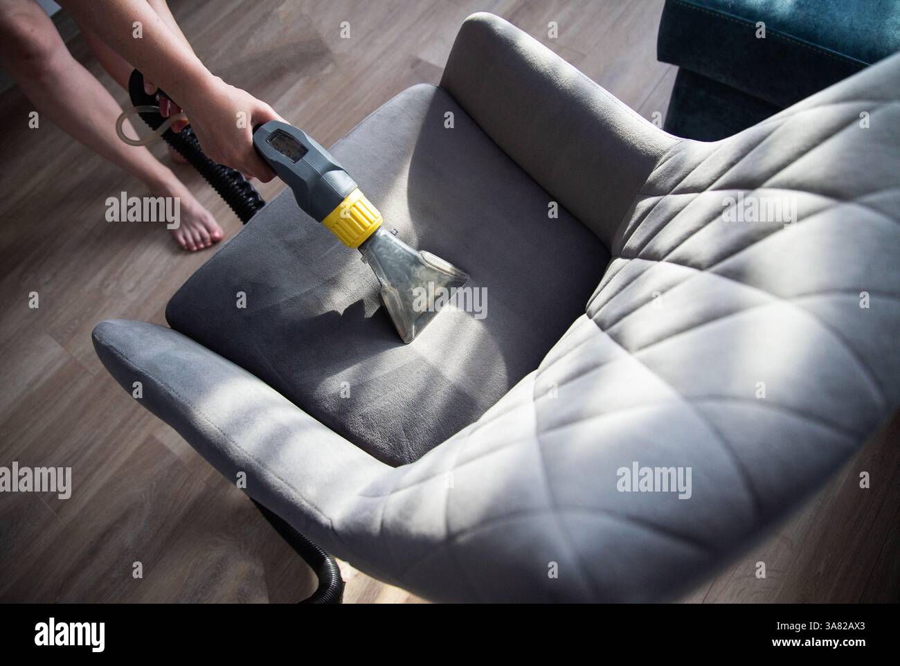 The hands of a girl with a washing vacuum cleaner clean and wash the ...