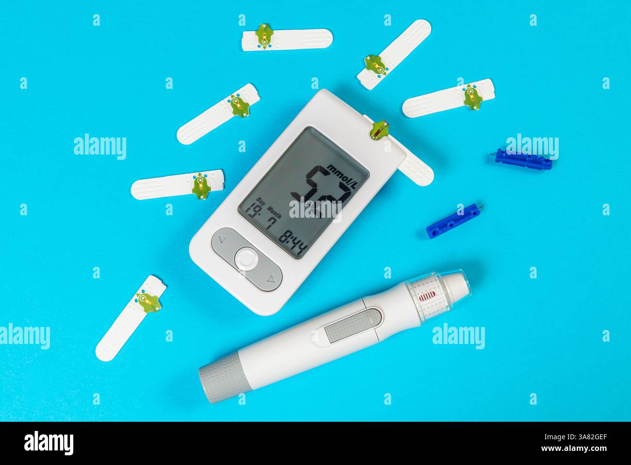 Blood glucose meter and insulin pen placed on a blue background with ...