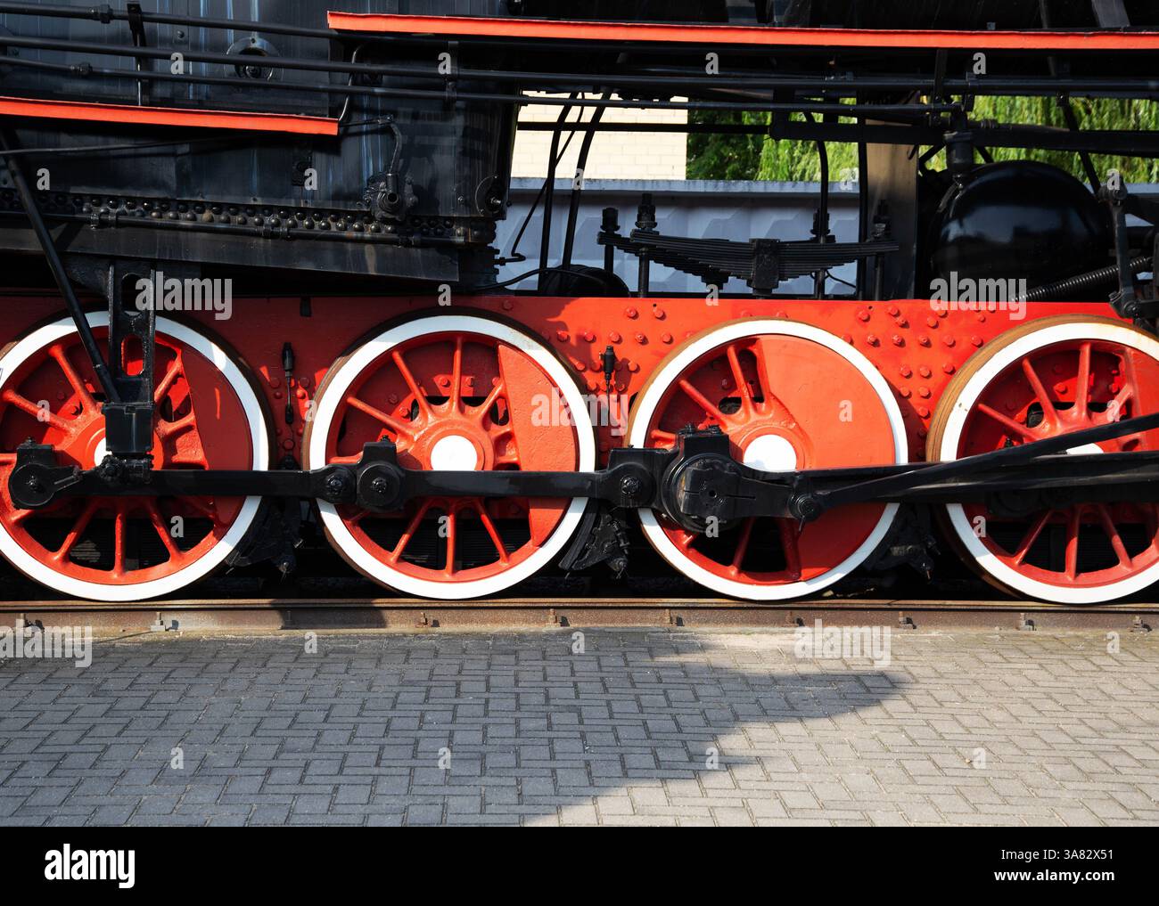 Large metal wheels of a steam locomotive transmitting traction from the ...