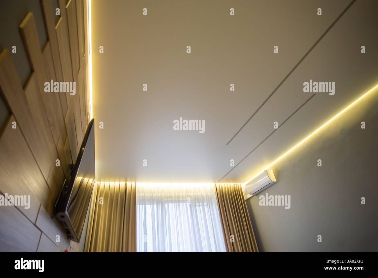 Beautiful modern stretch ceiling with yellow LED lines around the ...