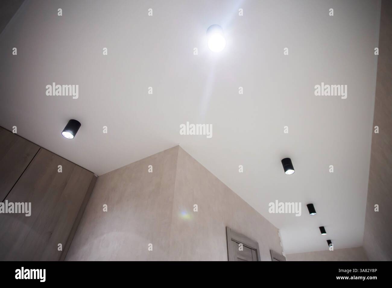 Stylish modern black spotlights on a suspended ceiling in the hallway ...