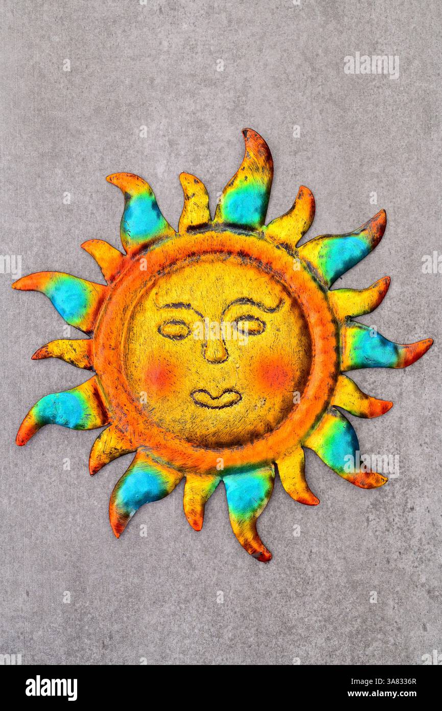 Tin model of sun with rays and face without expression vividly coloured ...