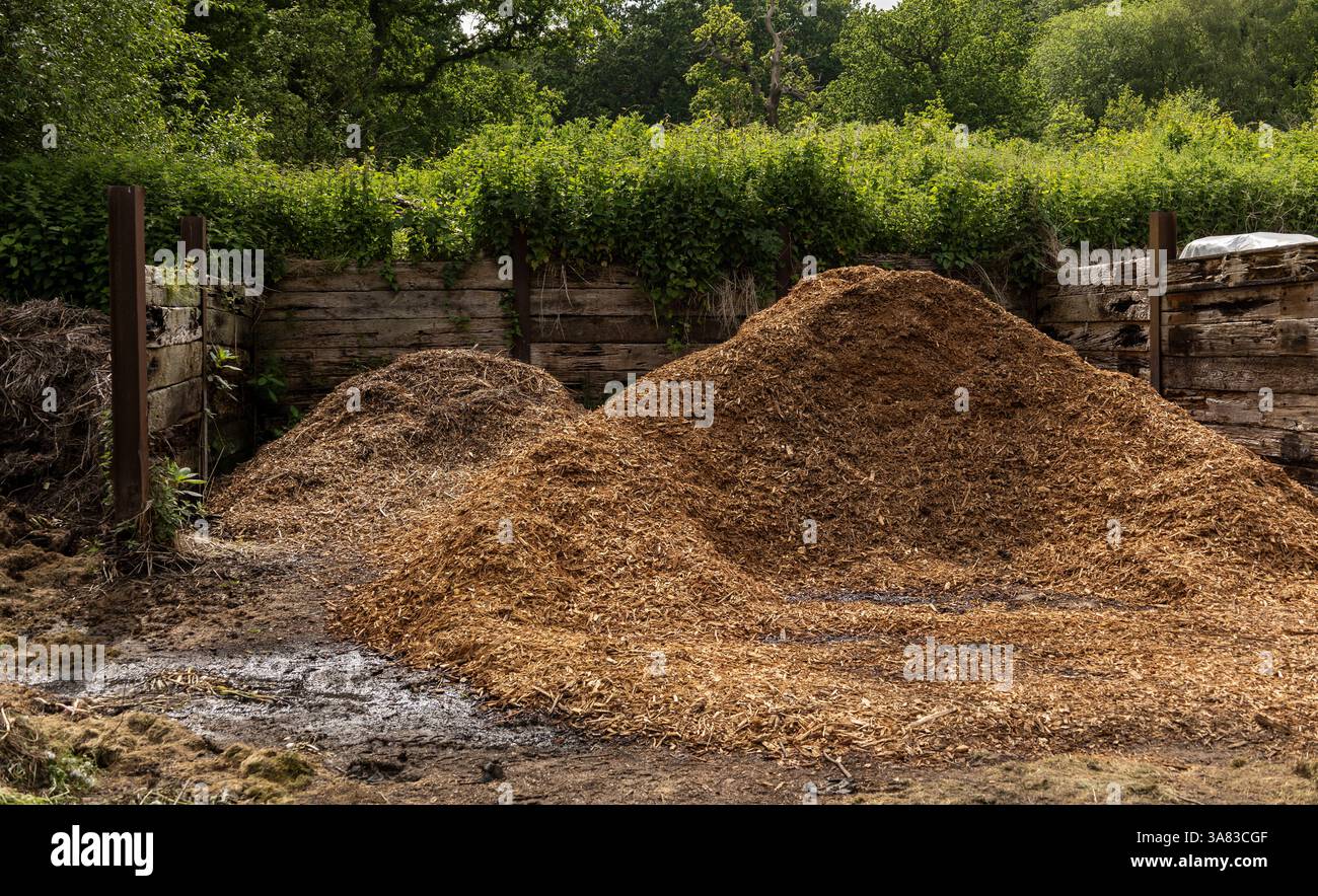 prepared heaps of wood mulch, chippings for use in the gardening ...