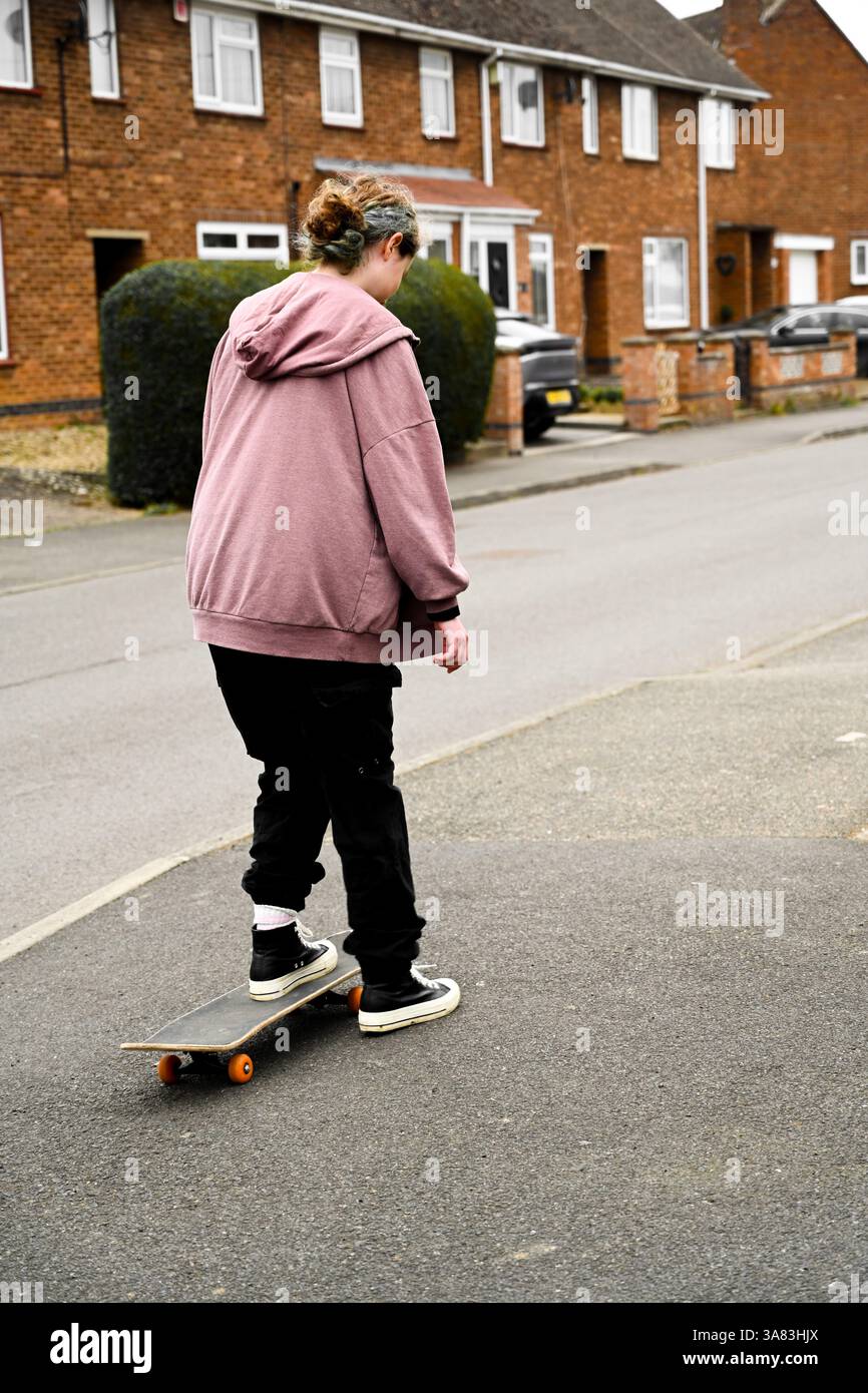 Teen age young girl with skate in the street, seen from behind Stock ...