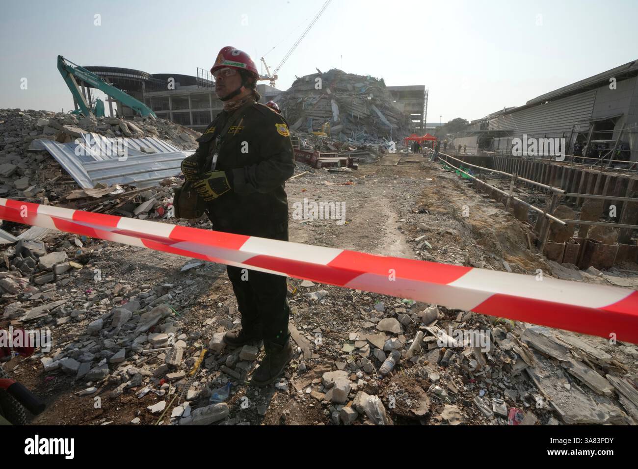 A rescuer walks at the site of a high-rise building under construction ...