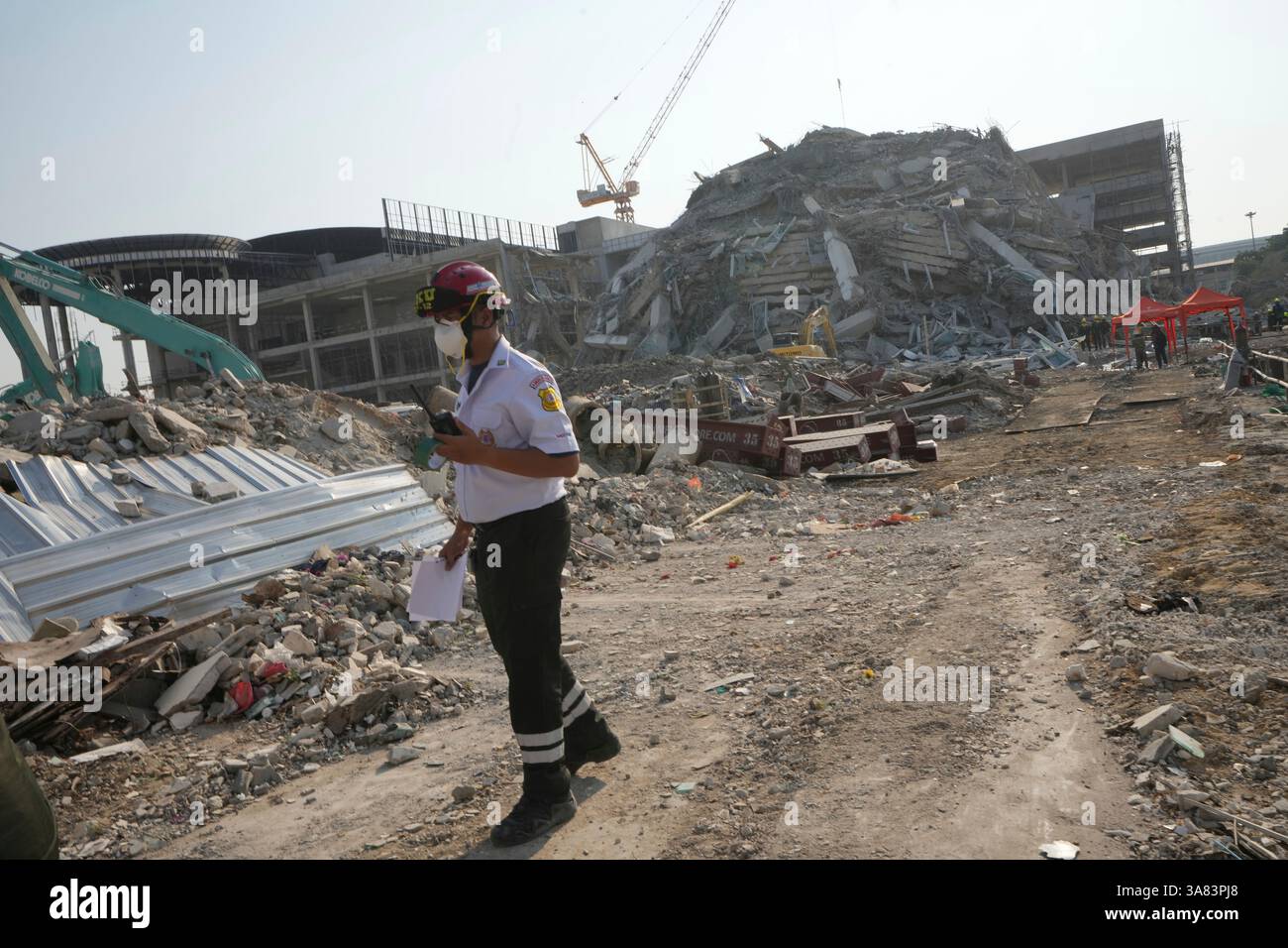 A rescuer walks at the site of a high-rise building under construction ...