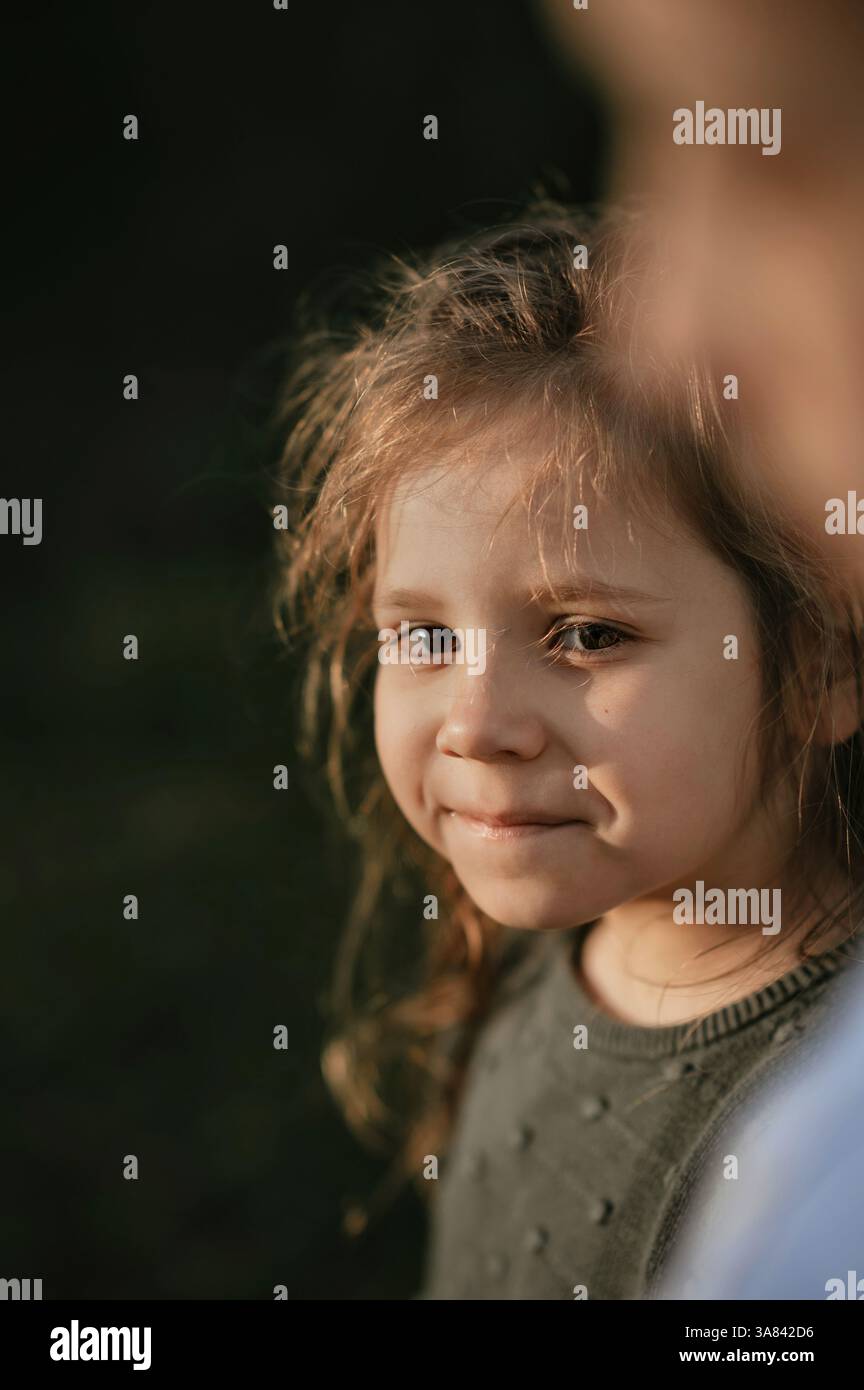 sister peeking out over brother. looking at camera Stock Photo - Alamy