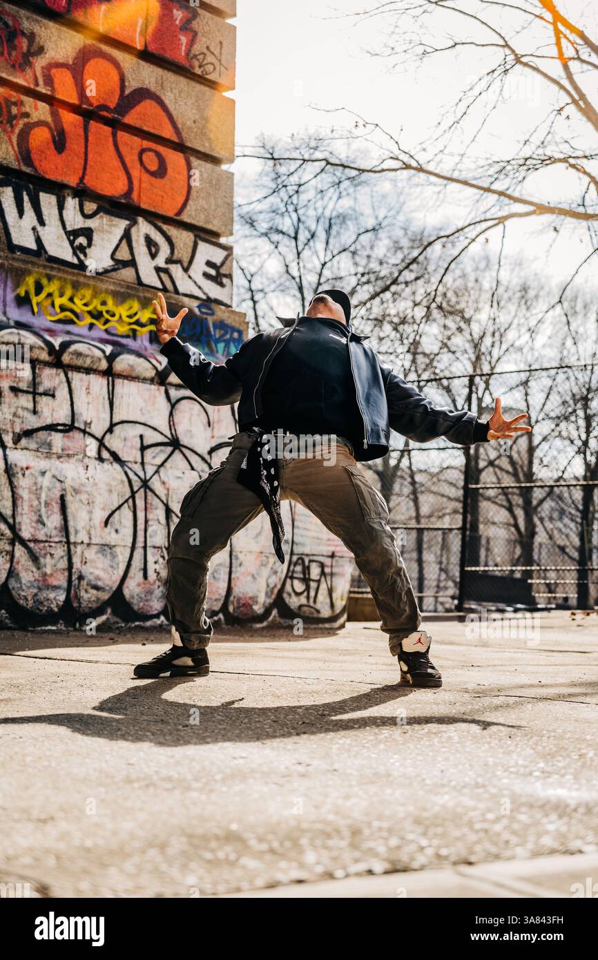 Street dancer leans back with power near graffiti-covered wall Stock ...