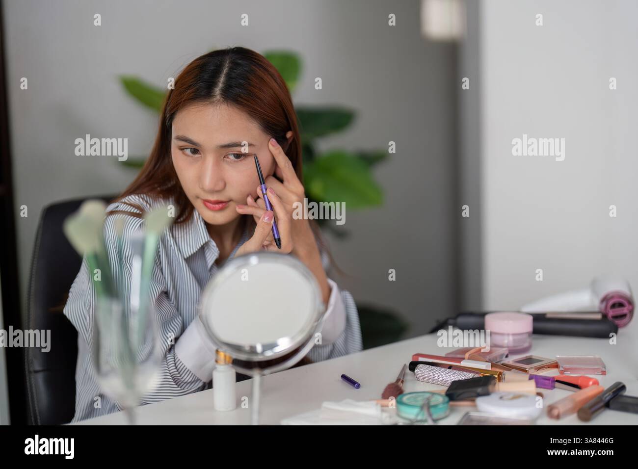 Beauty and Eyebrow Styling. A woman applying eyebrow pencil to shape ...