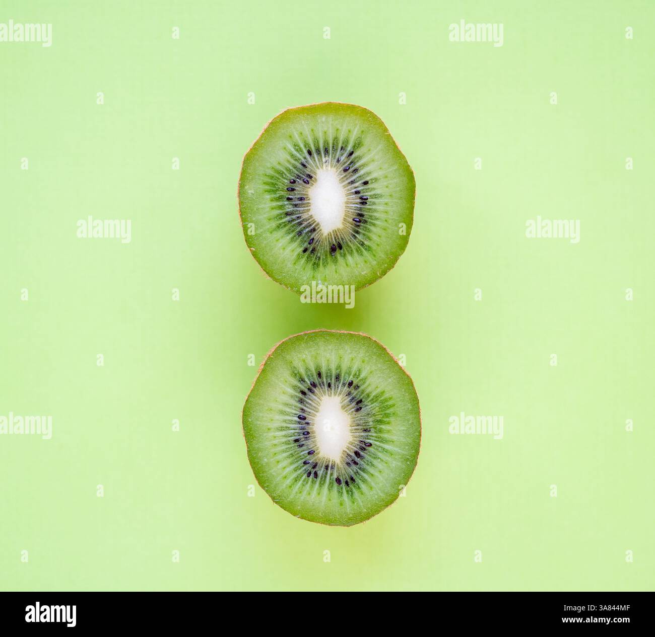 Isolated cross section of kiwi fruit on solid green background Stock ...
