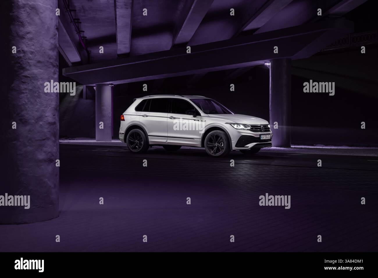 Silver Volkswagen Tiguan under purple-illuminated bridge at night ...