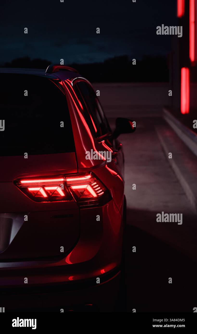 Tail light of modern car in night city. Close-up image of right glowing ...