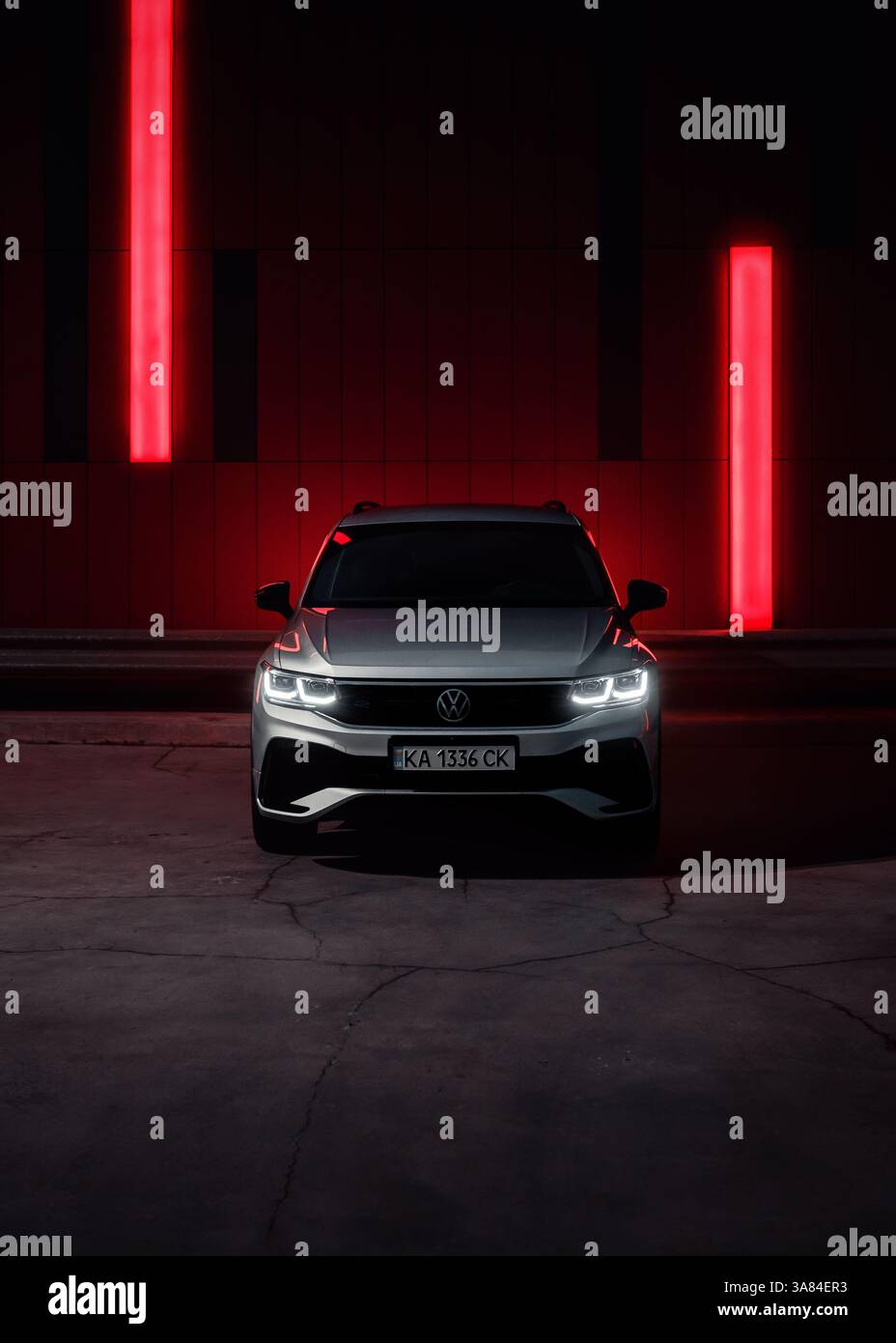 Silver VW Tiguan at night near a wall with red glowing stripes ...