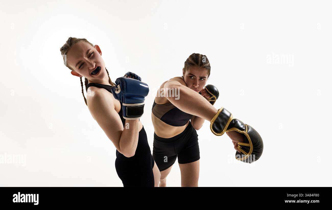 Intense battle moment. Young woman, Thai boxing athlete delivering ...