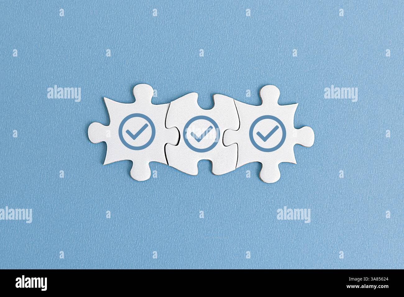 Three white puzzle pieces with white checkmarks are arranged in a row ...