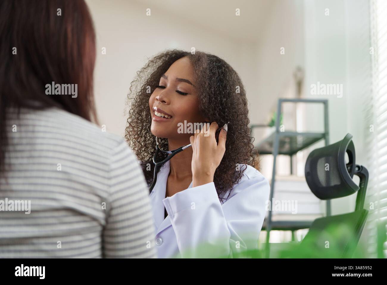 Medical Assessment. A doctor uses a stethoscope while talking to a ...