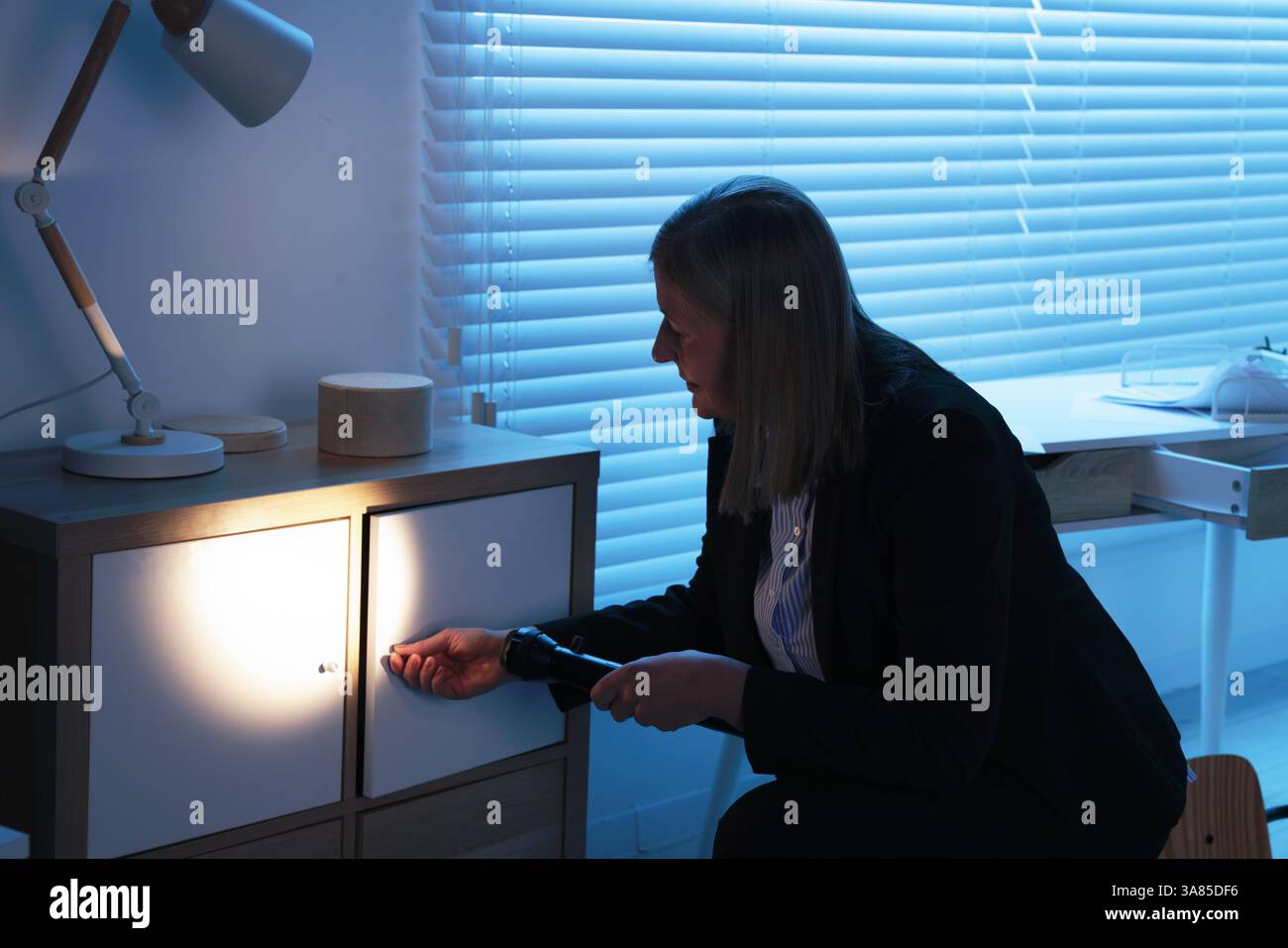 Forensic expert with flashlight working at crime scene indoors Stock ...