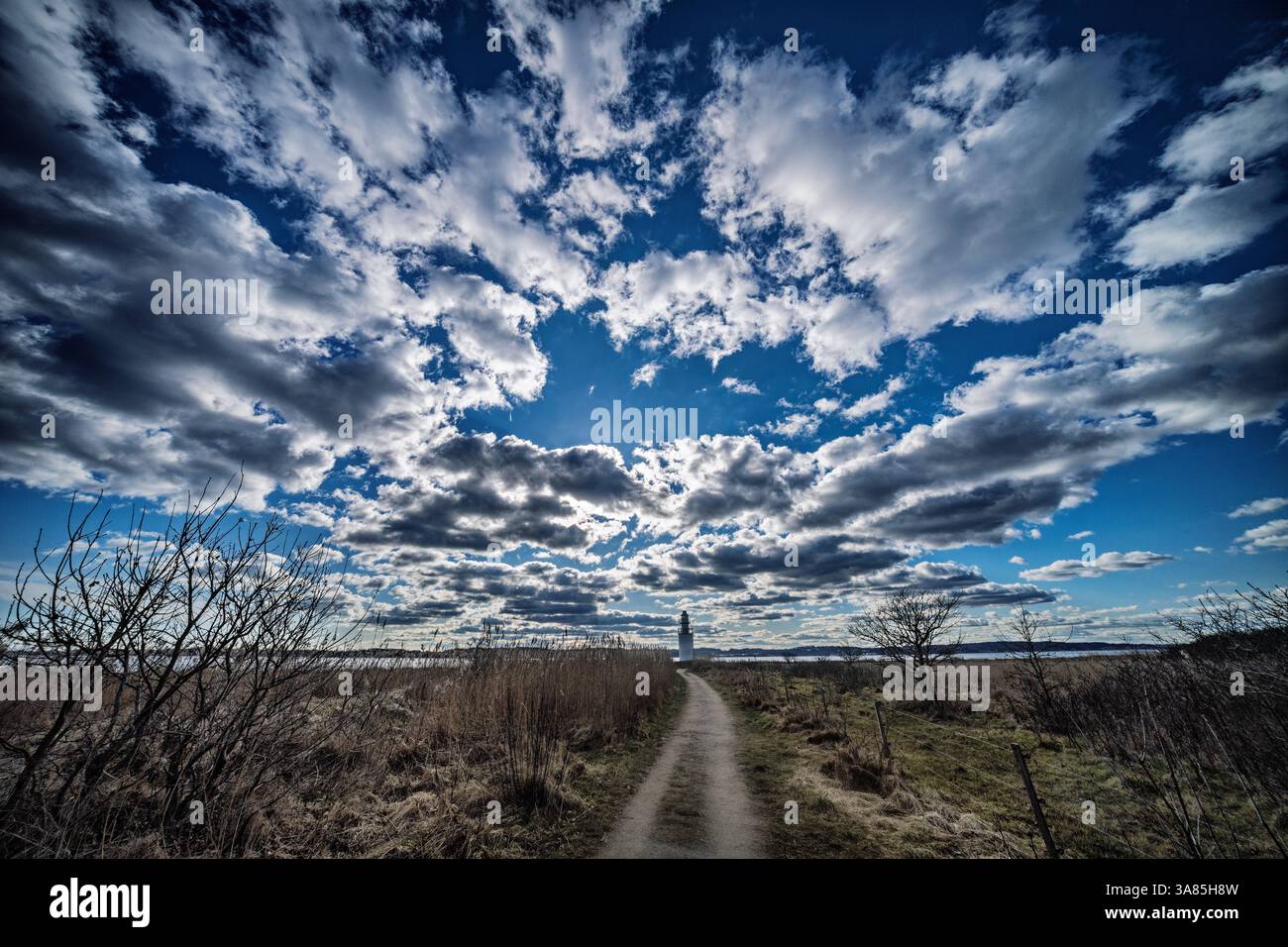 A serene lighthouse surrounded by coastal landscape, featuring a ...