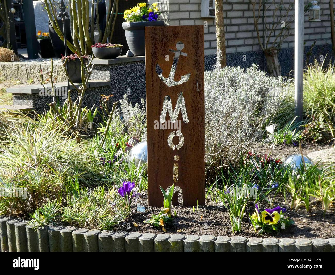 Metal Schild mit dem Buchstaben Moin und einem Anker steht als Garten ...