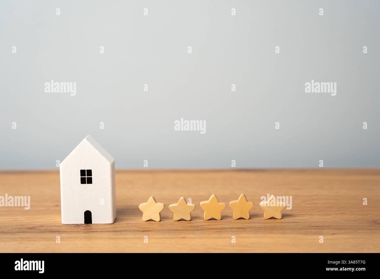 Five stars and a wooden house on a gray background. The concept of the ...