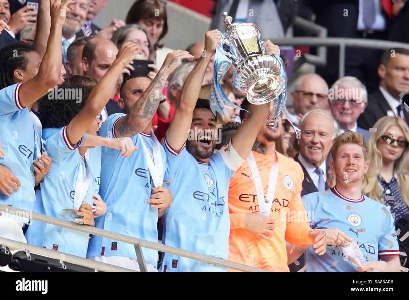 FILE - Manchester City's Ilkay Gundogan, center, holds up the winners ...